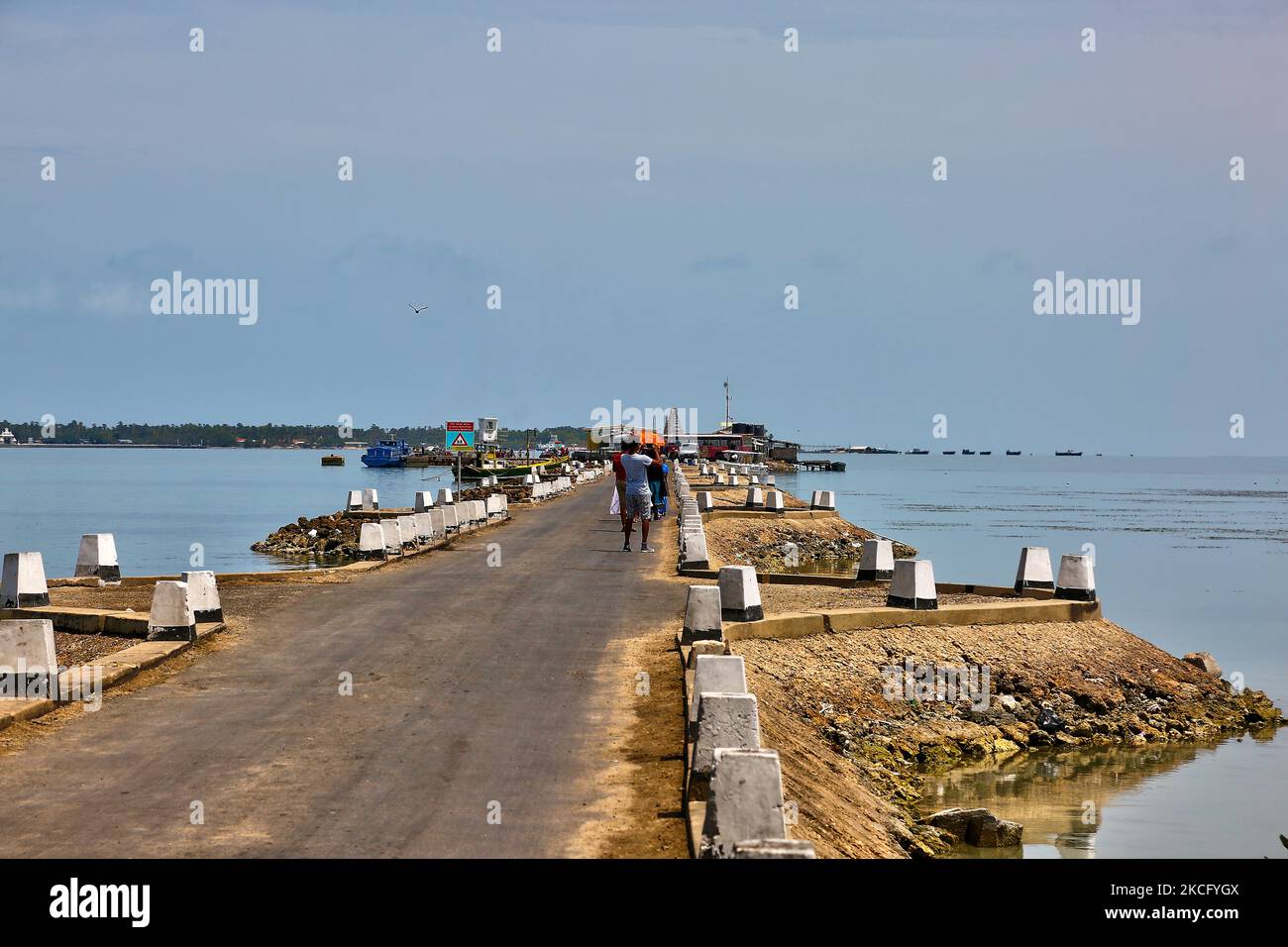 People walk along a small road at Kurikadduwan harbour in the Jaffna ...