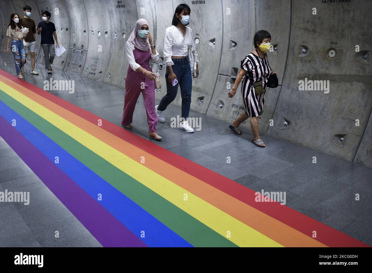 People passing on a rainbow painted to mark Pride Month celebrations of ...