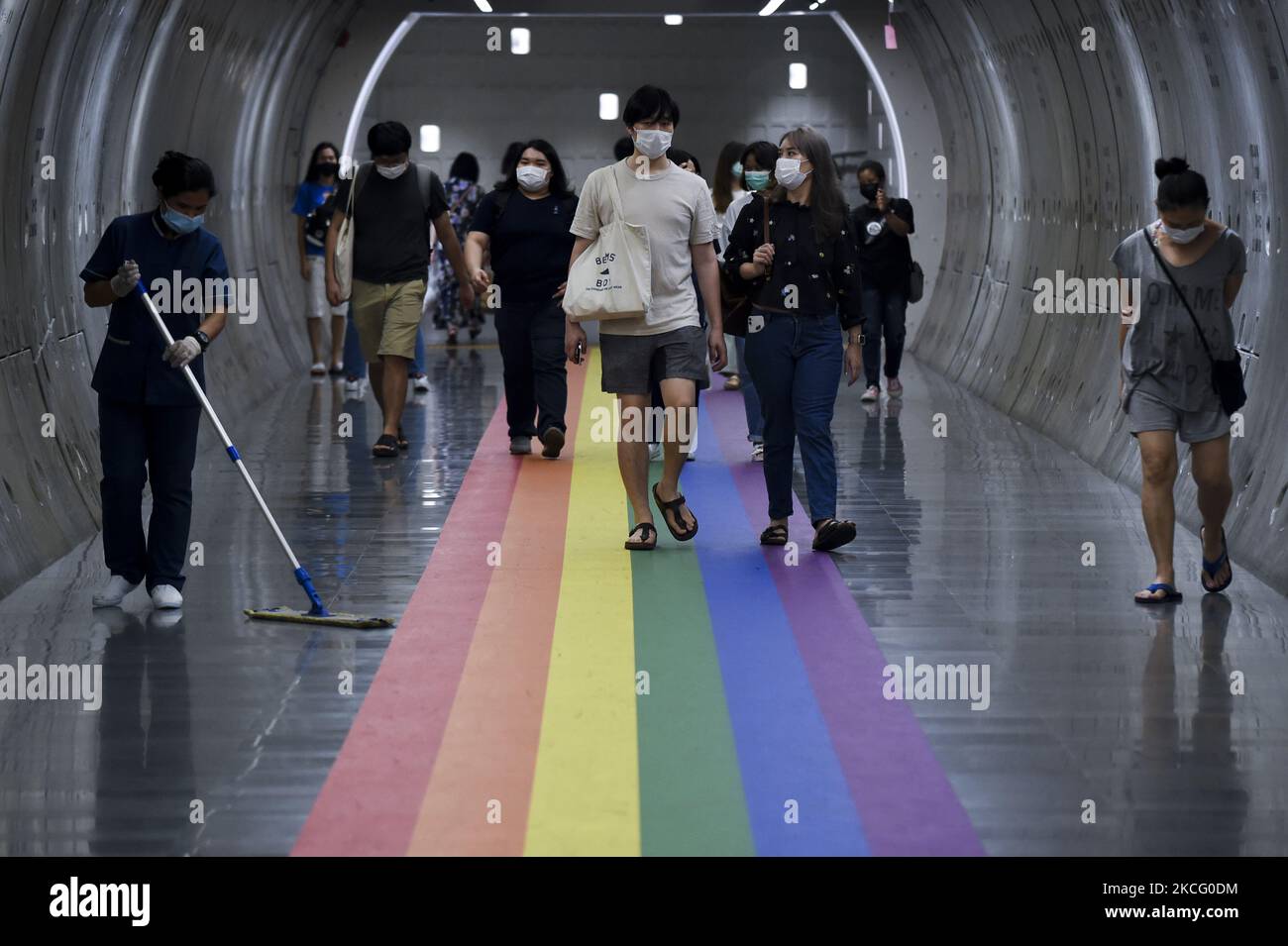 People passing on a rainbow painted to mark Pride Month celebrations of ...