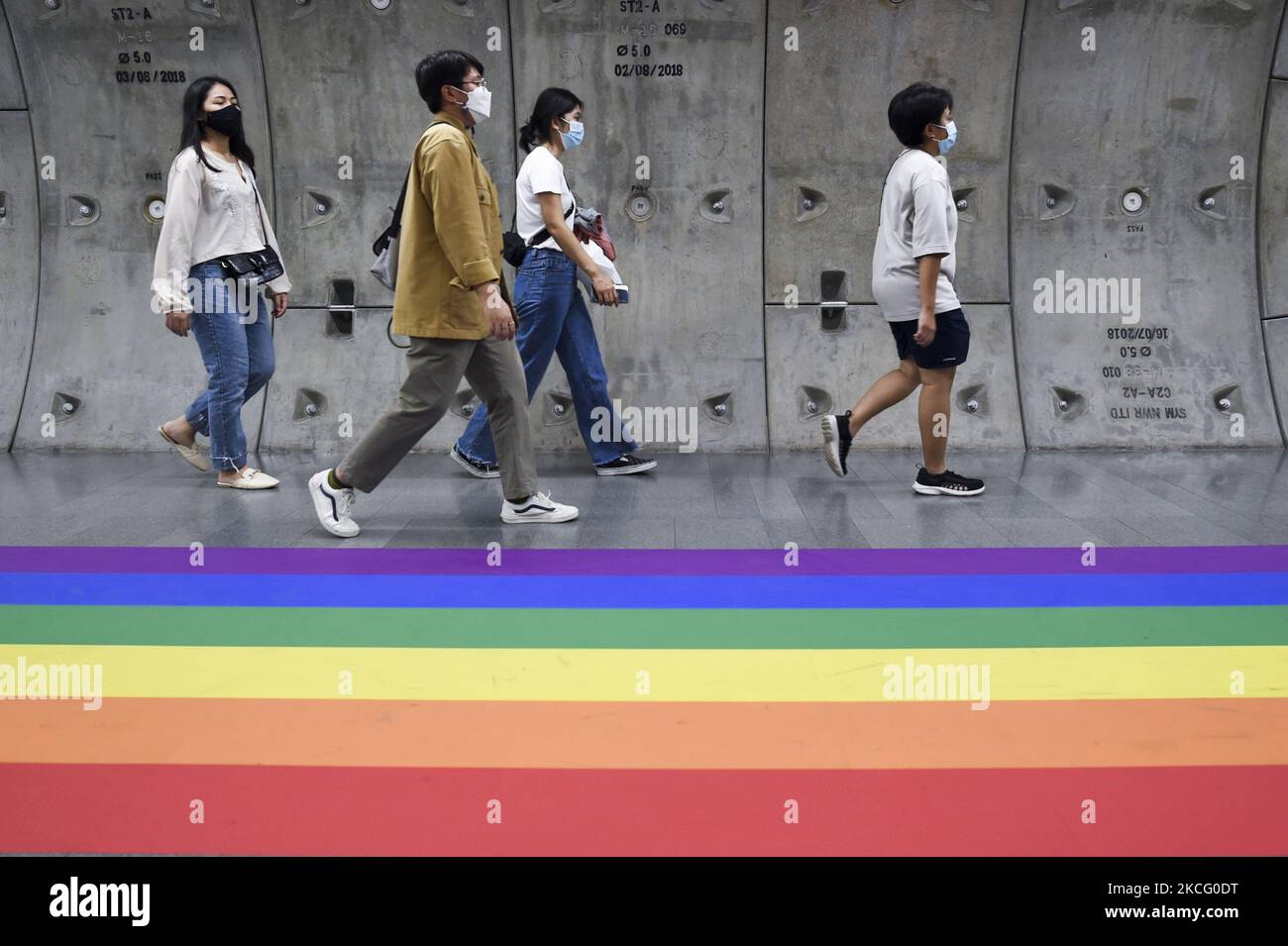 People passing on a rainbow painted to mark Pride Month celebrations of ...