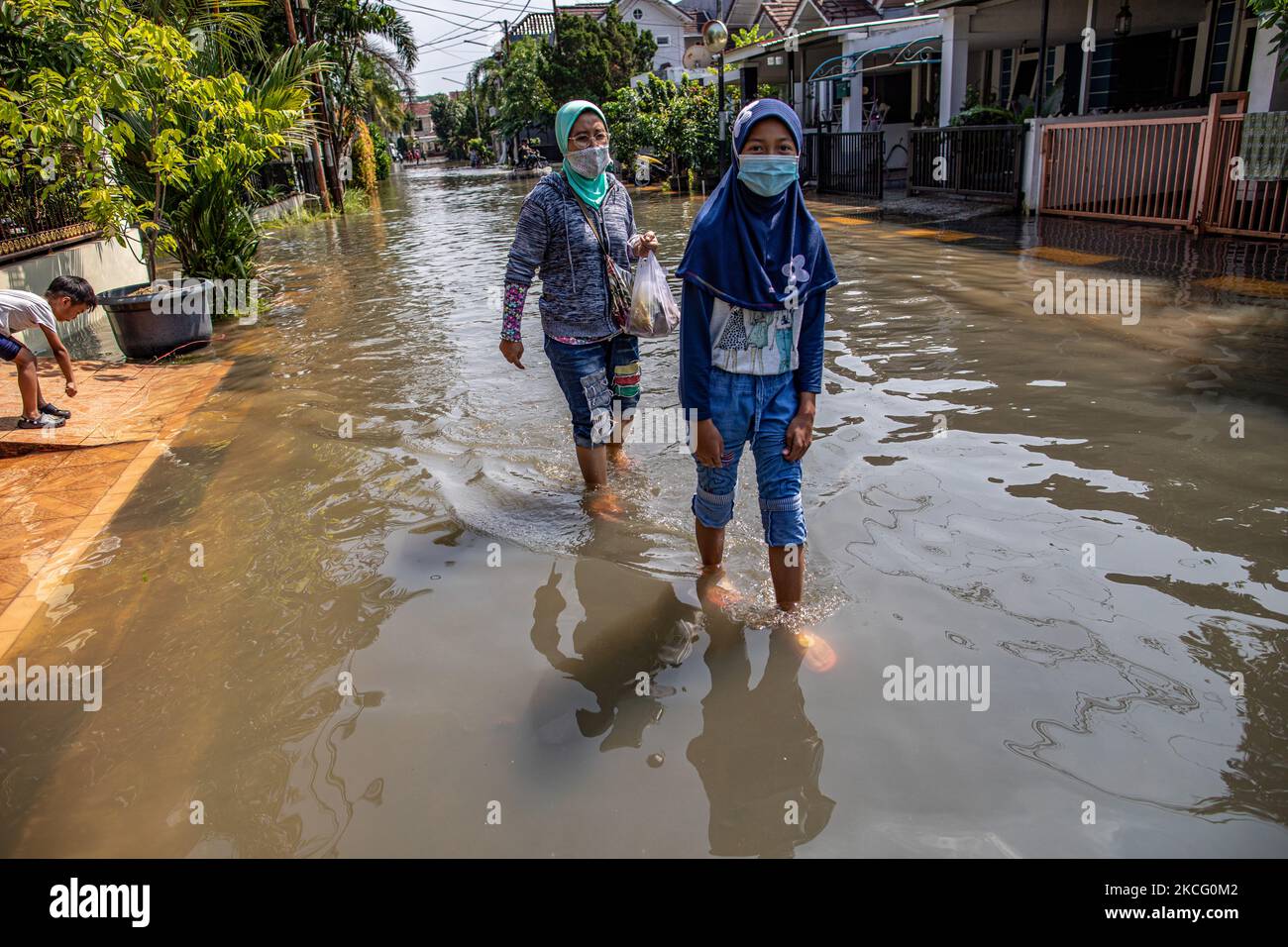 Mother and daughter bring lunch to their flooded house. Floods that hit ...