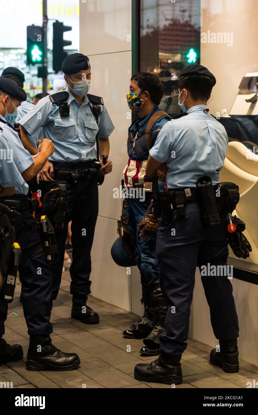 A man with a Captain America costume is controlled by the police in ...