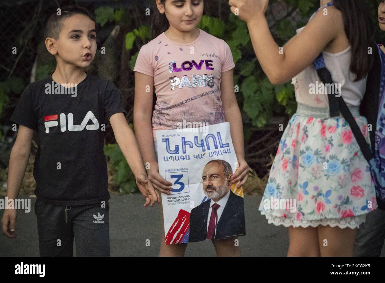 Kids hold a banner with the face of Nikol Pashinyan, main cadidate of ...