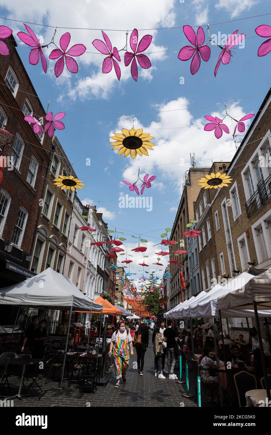 LONDON, UNITED KINGDOM - JUNE 16, 2021: People walk under a floating ...