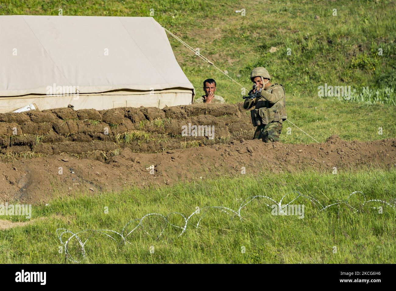 Azeri soldier points his sniper rifle to armenian positions from his ...