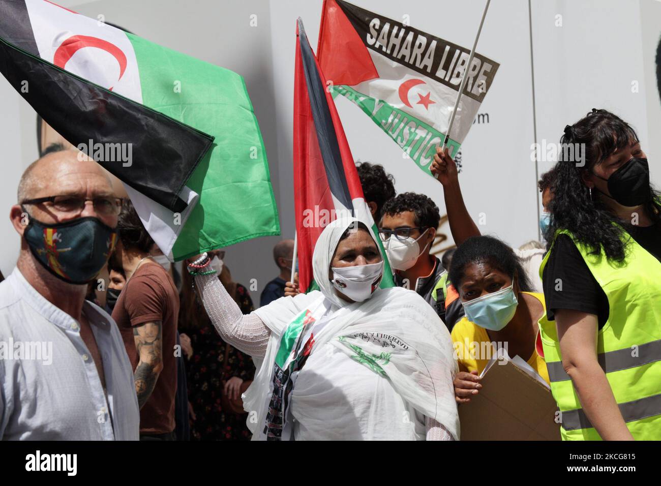 Saharawi women wearing masks display Saharawi flags during the ...