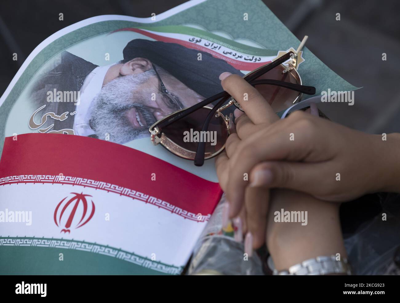 A female supporter of the Iranian president elect Ebrahim Raisi holds a ...