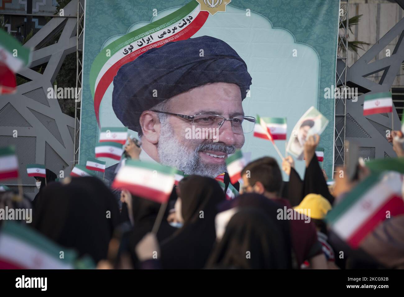 Supporters of the Iranian president elect Ebrahim Raisi wave Iran flags ...
