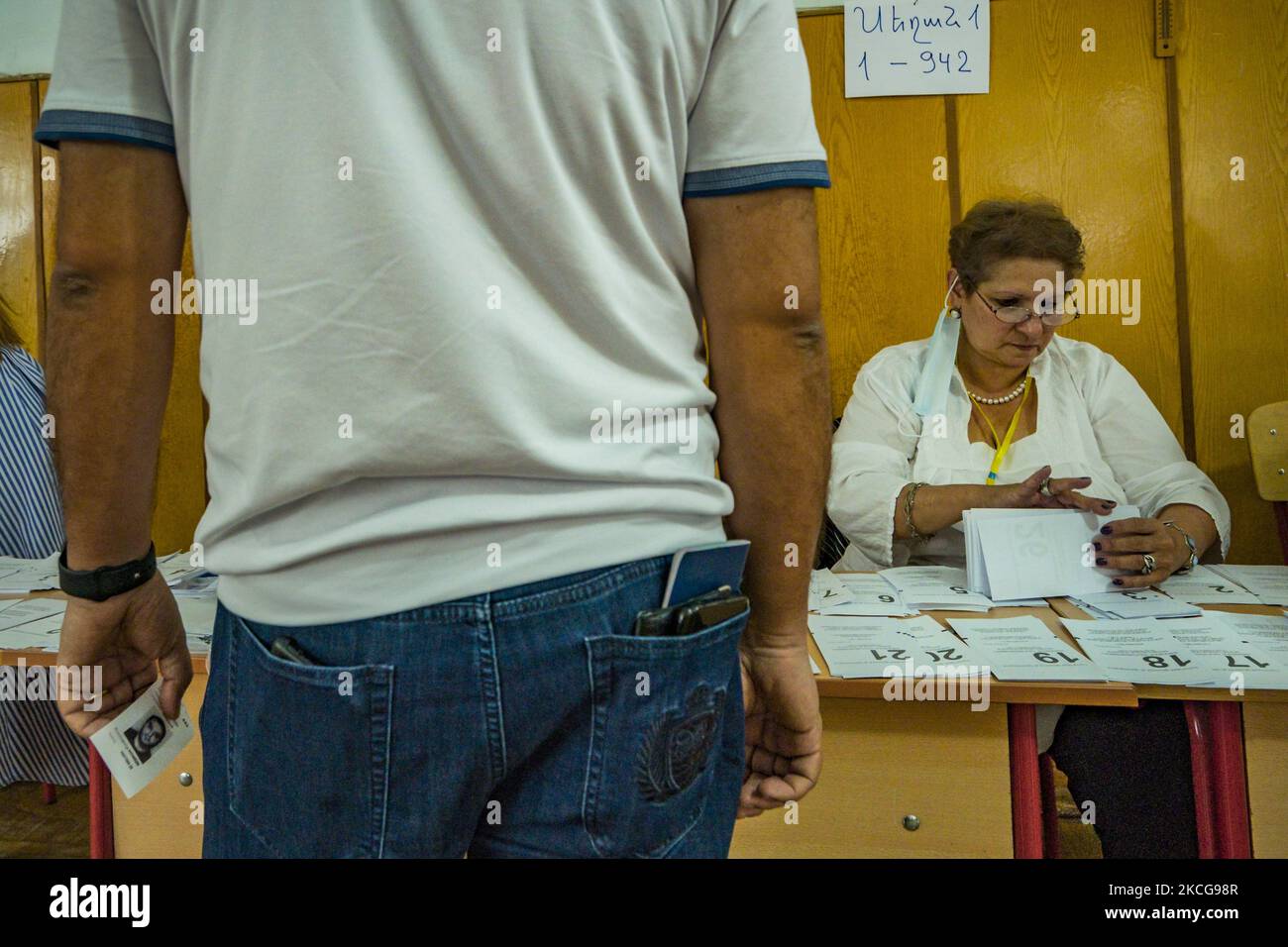 A man with his identification ticket waits their turn to take the ...