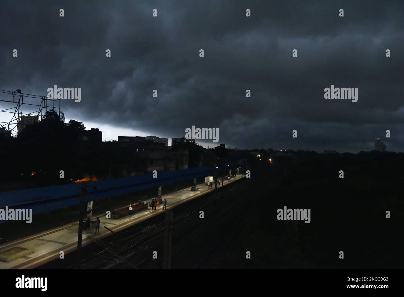 Dark clouds formation can be seen over a suburban railway station in ...