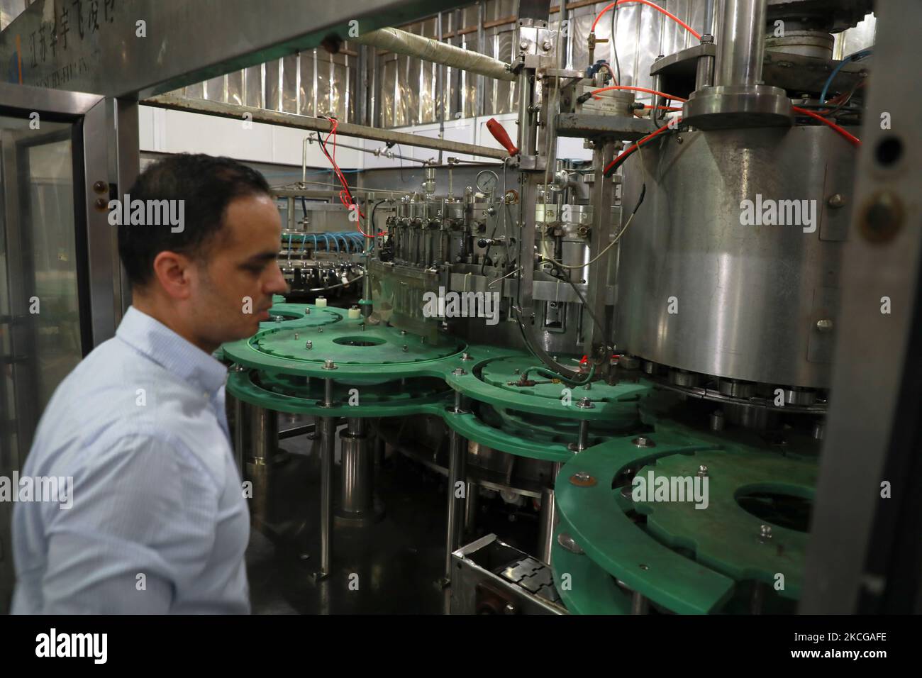 A Palestinian employee cleans an empty production line at the PEPSI ...