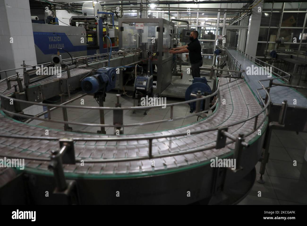A Palestinian employee cleans an empty production line at the PEPSI ...