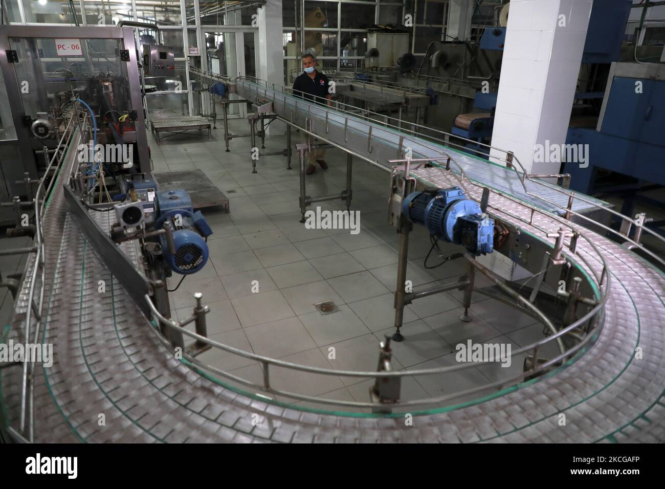 A Palestinian employee cleans an empty production line at the PEPSI ...