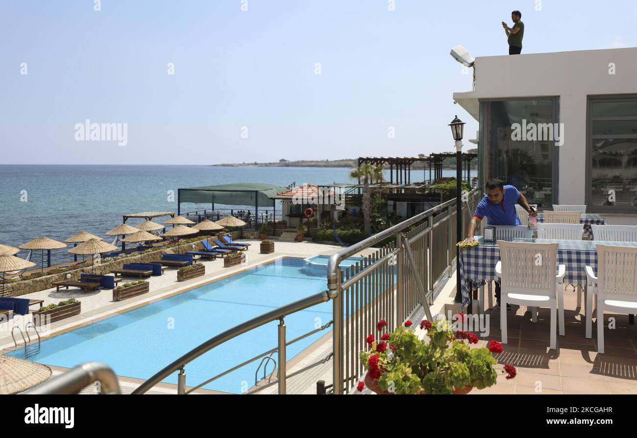 A hotel worker cleans the table after breakfast at the Manolya Hotel in ...