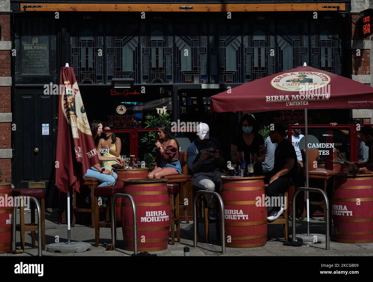 People drinking beer outside a pub in Dublin city center. On Monday, 21 ...