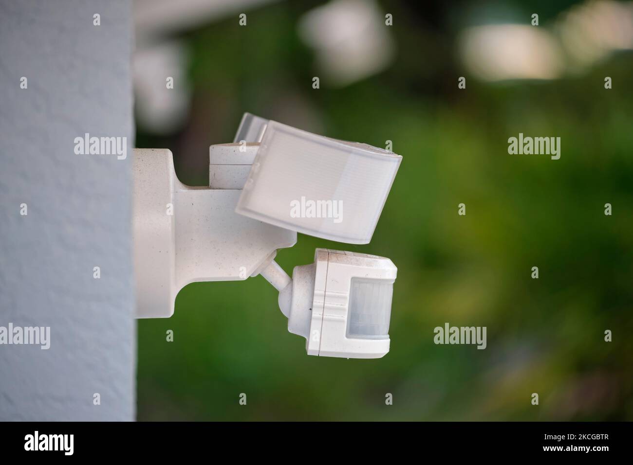 Motion sensor with light detector mounted on exterior wall of private ...