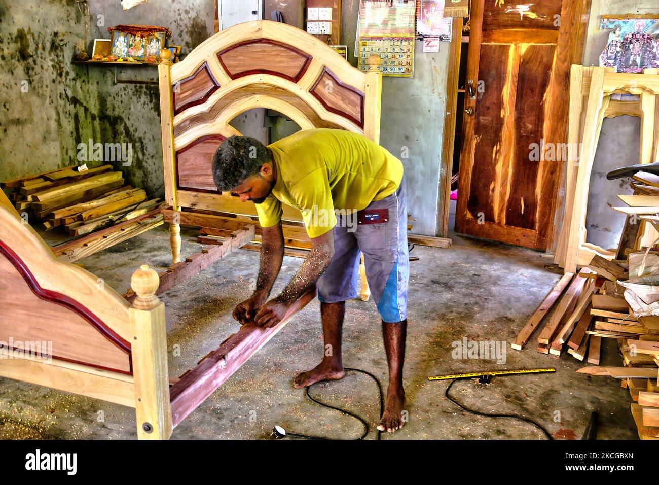 Carpenter constructs a fancy wooden bed frame at a small workshop in ...