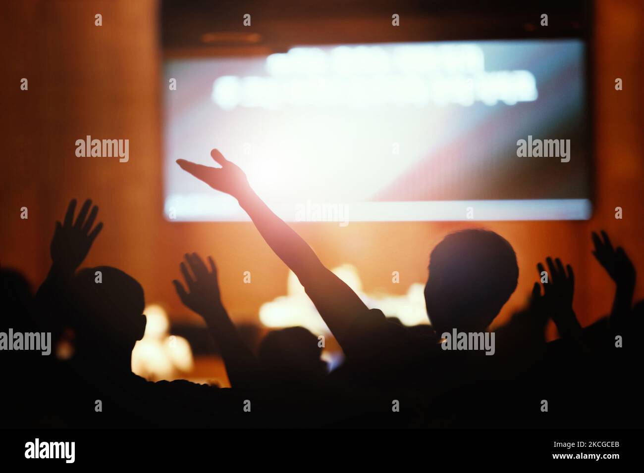 Passionate worship with hands raised and praising and graceful church prayer time background ...