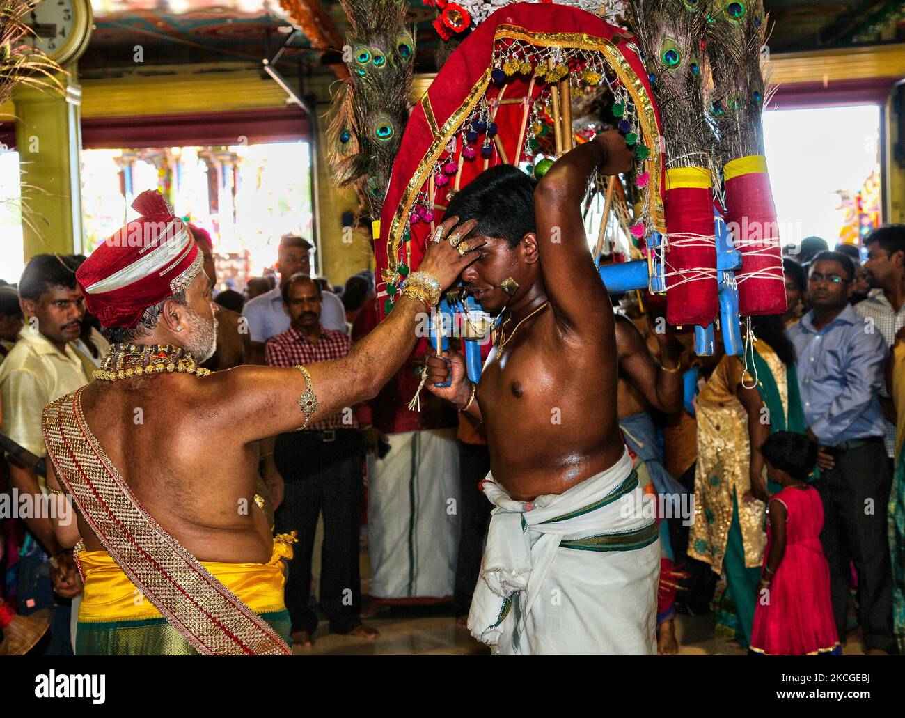 Tamil Hindu devotee receives blessings from a Hindu priest after ...