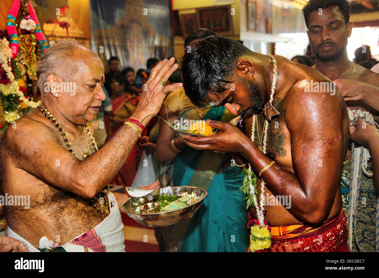 Tamil Hindu devotee receives blessings from a Hindu priest after ...