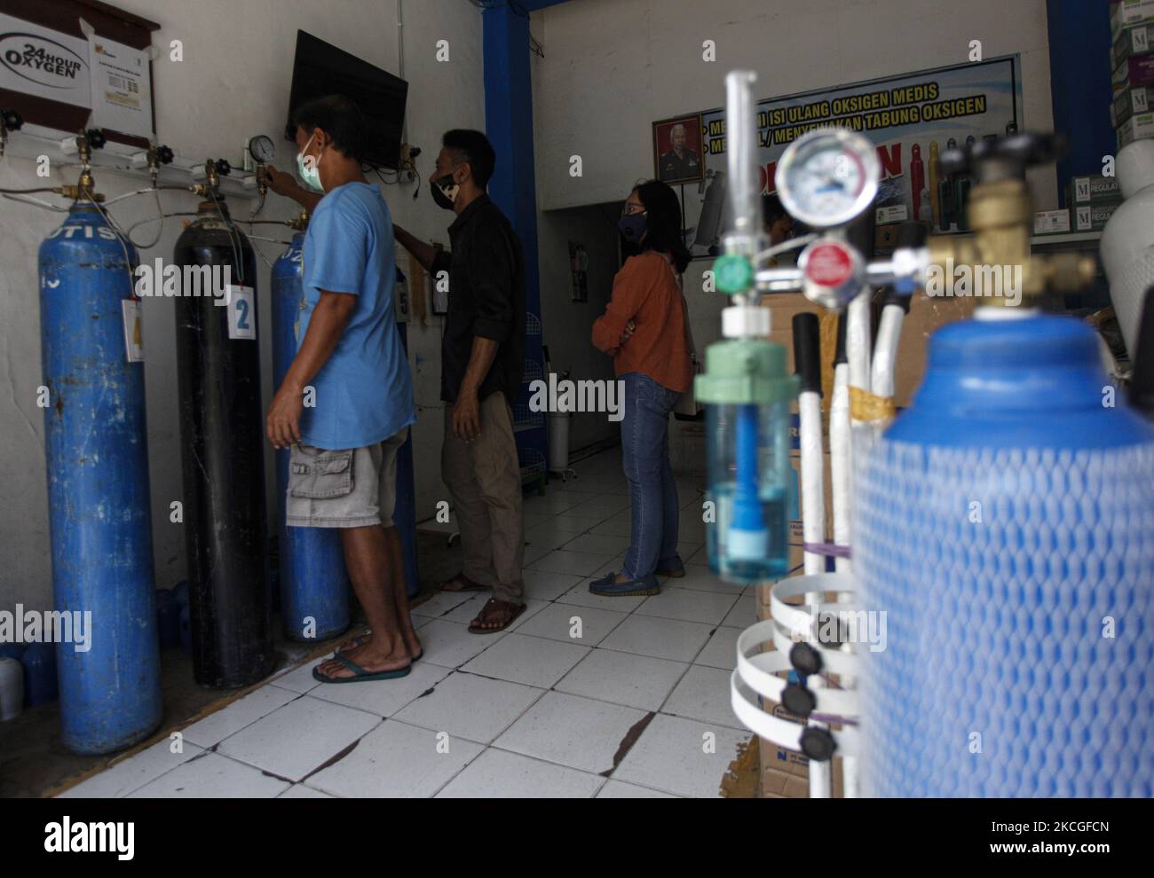 A worker refills oxygen cylinder for treating patients as the demand ...