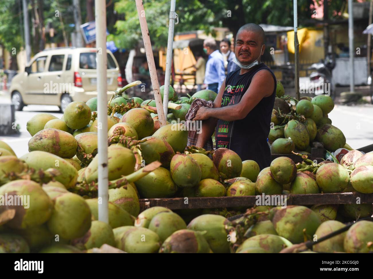 Street vendor selling coconut during a hot summer day, in Guwahati ...