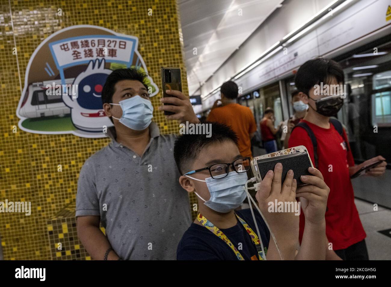 A Boy takes photos inside Sung Wong Toi Station while waiting to ride ...