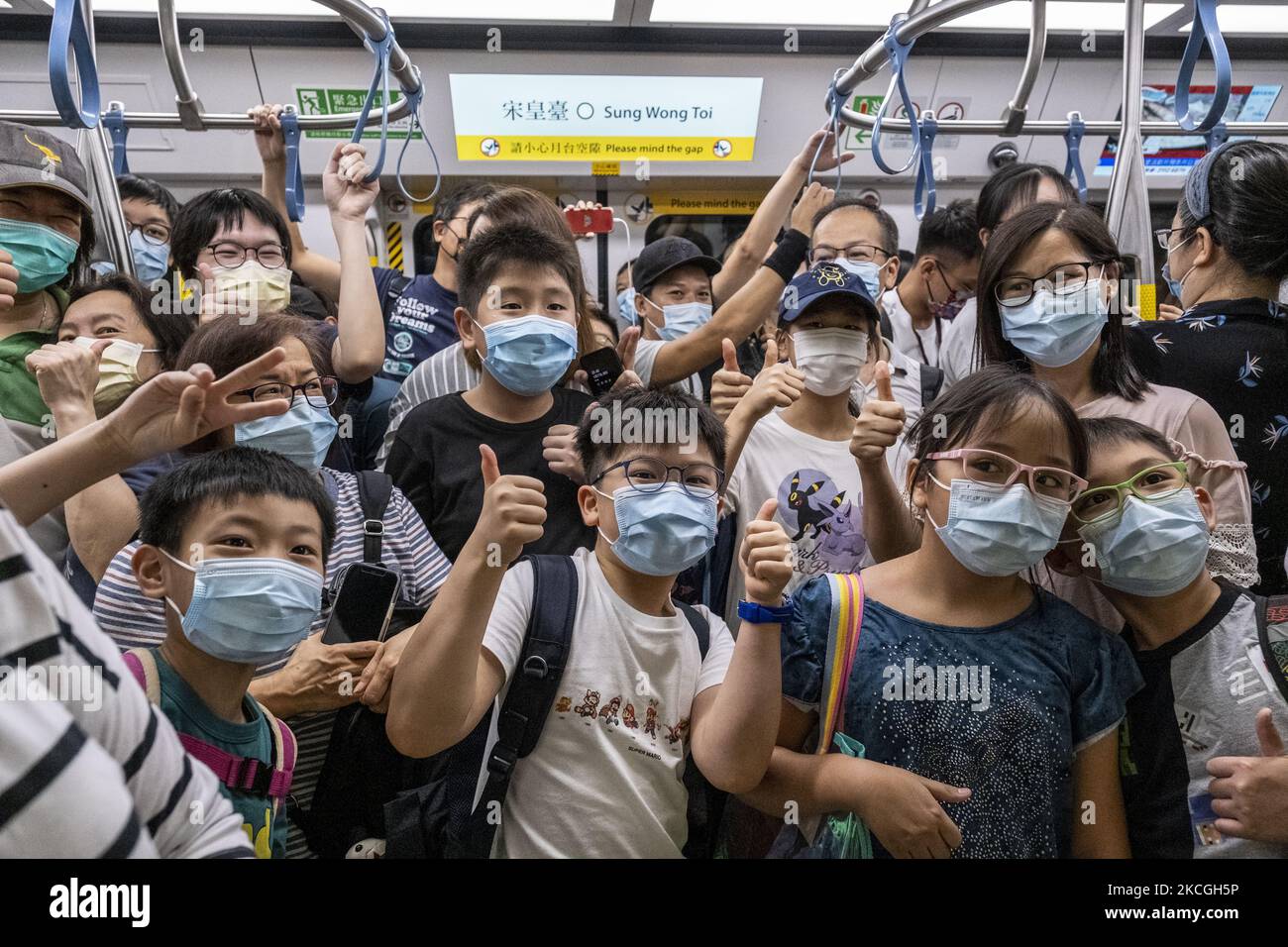 Passengers riding on the first train of the Tuen Ma Line in Hong Kong ...