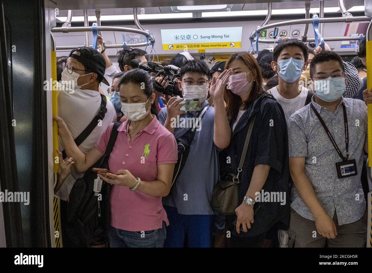 Passengers riding on the first train of the Tuen Ma Line in Hong Kong ...