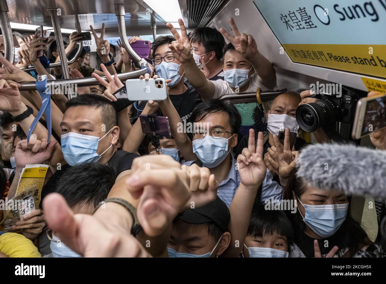 Passengers riding on the first train of the Tuen Ma Line in Hong Kong ...