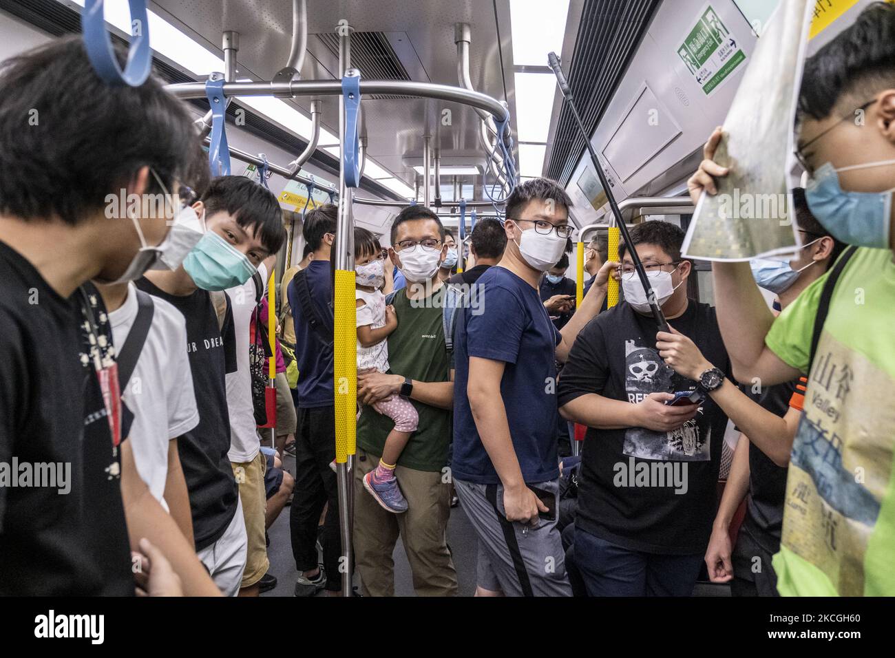 Passengers riding on the first train of the Tuen Ma Line in Hong Kong ...