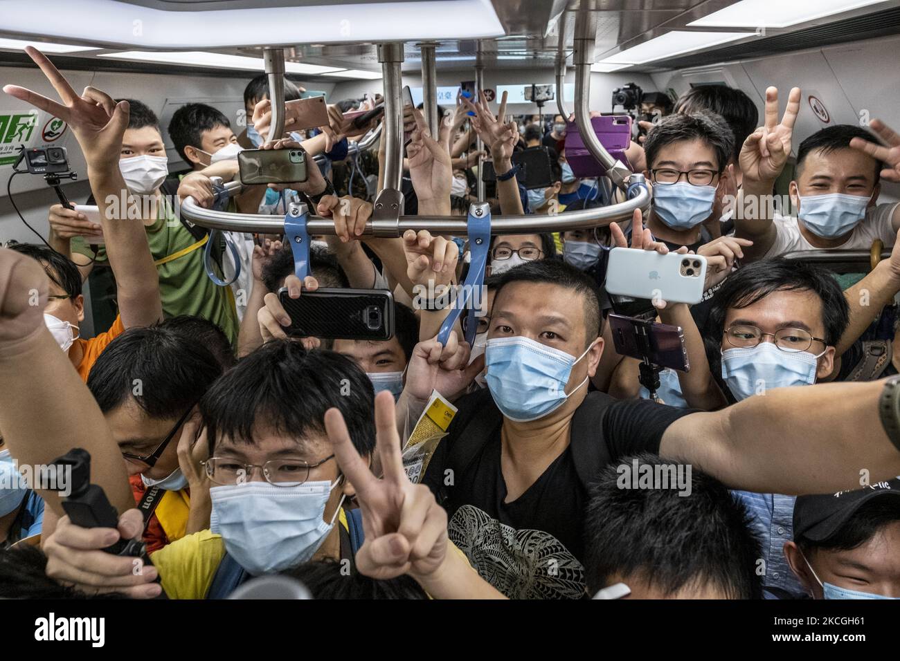 Passengers riding on the first train of the Tuen Ma Line in Hong Kong ...