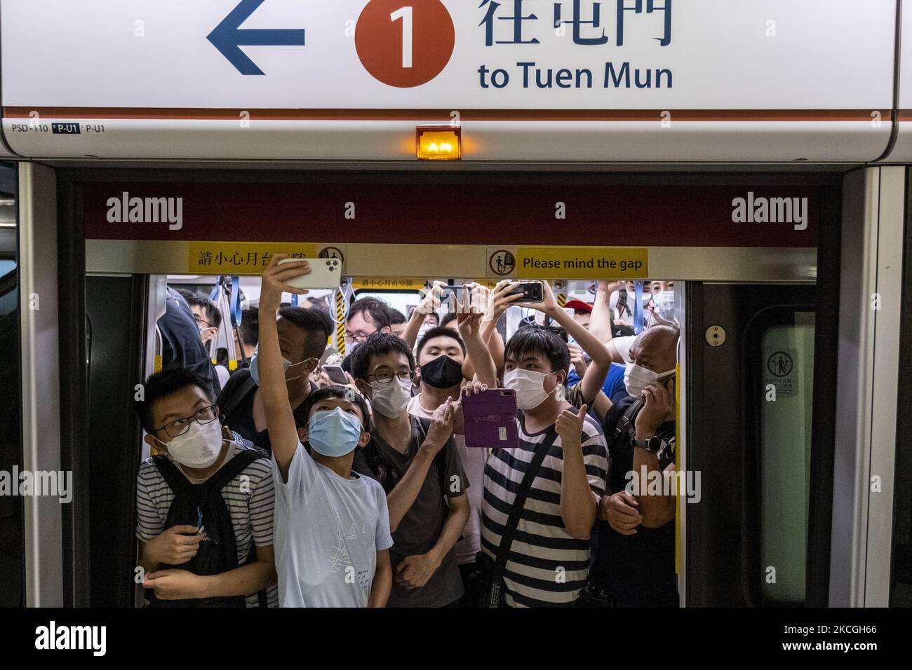 Passengers riding on the first train of the Tuen Ma Line in Hong Kong ...