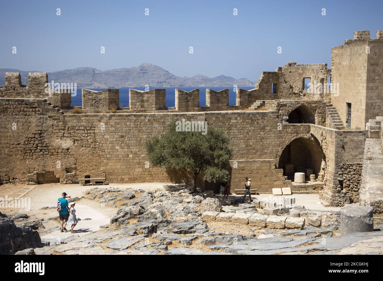Visitors walk in the acropolis (upper city) in Lindos on the island of ...