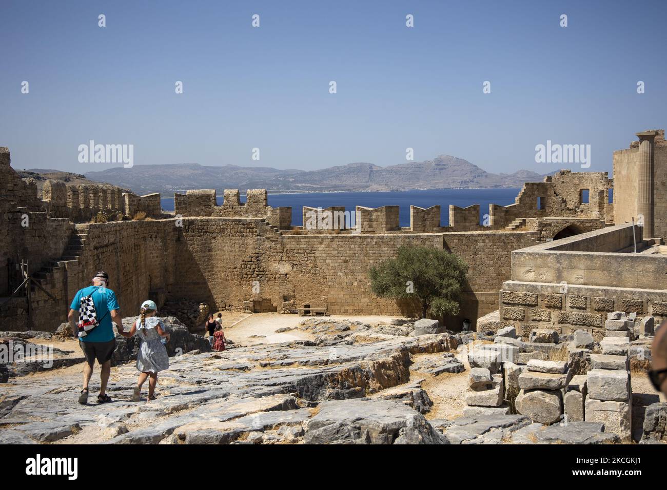 Visitors walk in the acropolis (upper city) in Lindos on the island of ...