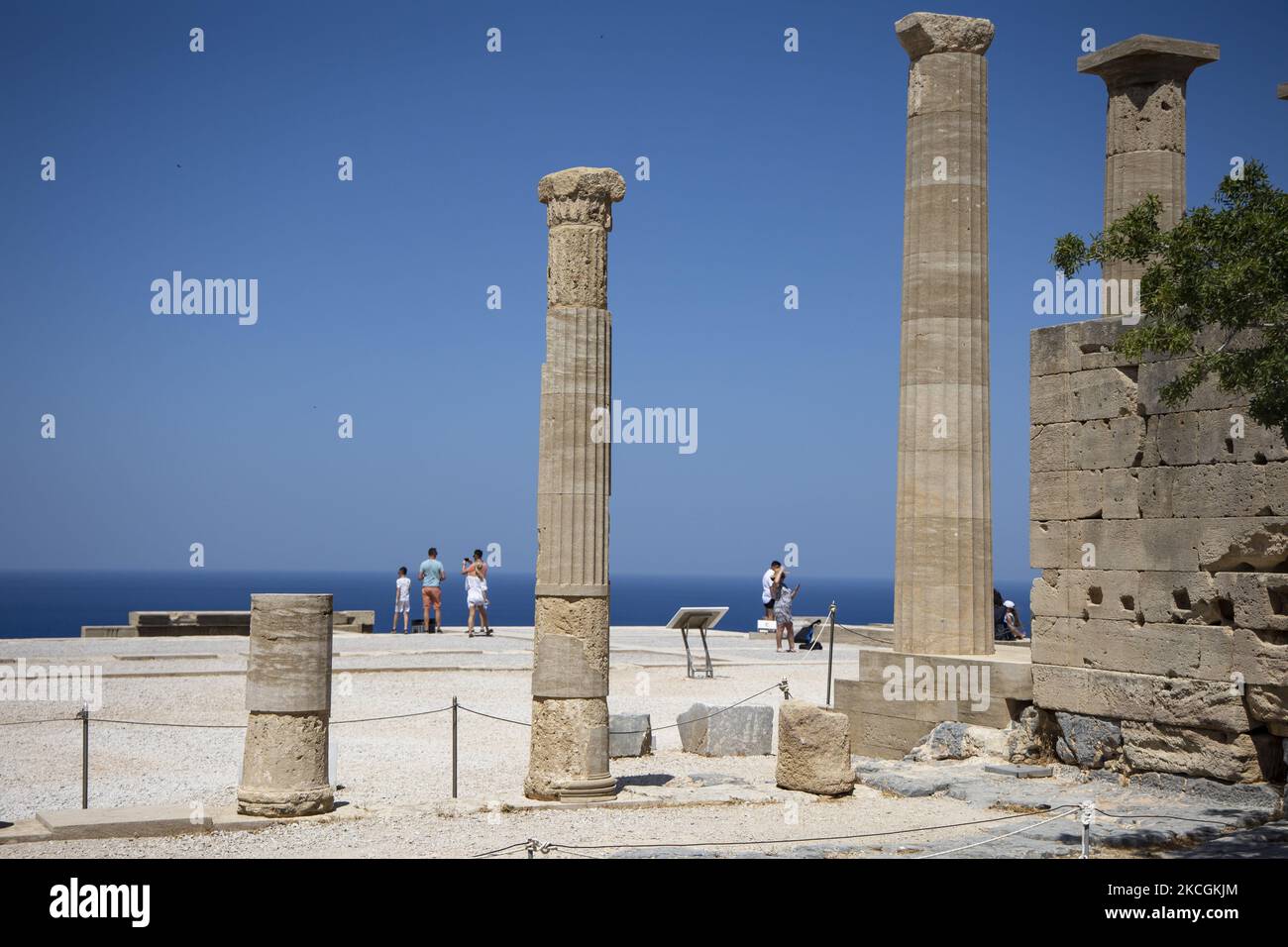 Visitors walk in the acropolis (upper city) in Lindos on the island of ...