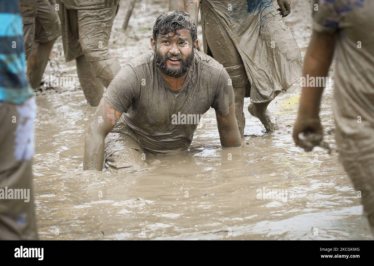 Nepalese People play in the mud as they plant rice saplings during ...