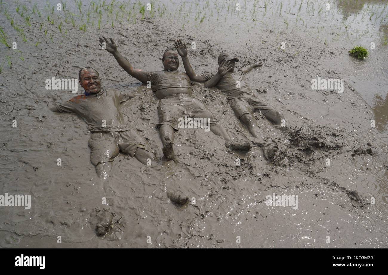 Farmers with mud-covered play in a paddy field during "National Paddy ...