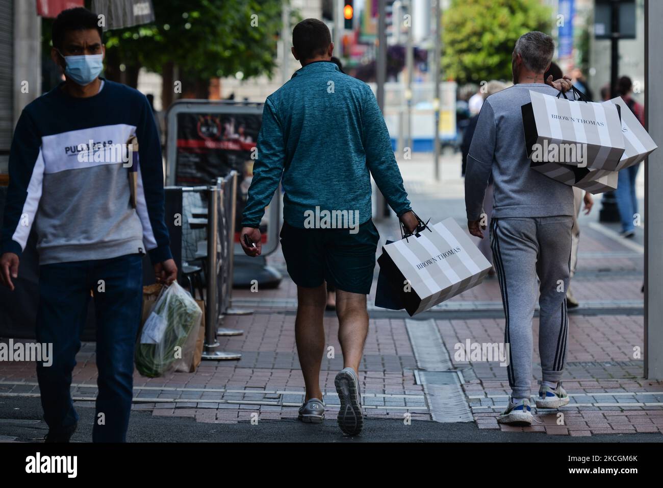 Two men walk with Brown Thomas shopping bags on Earl Street in Dublin ...