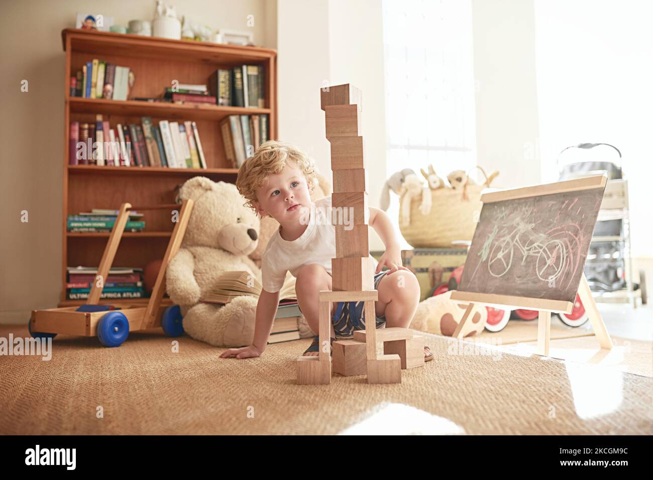 Hope this doesnt fall over. an adorable little boy playing with wooden ...