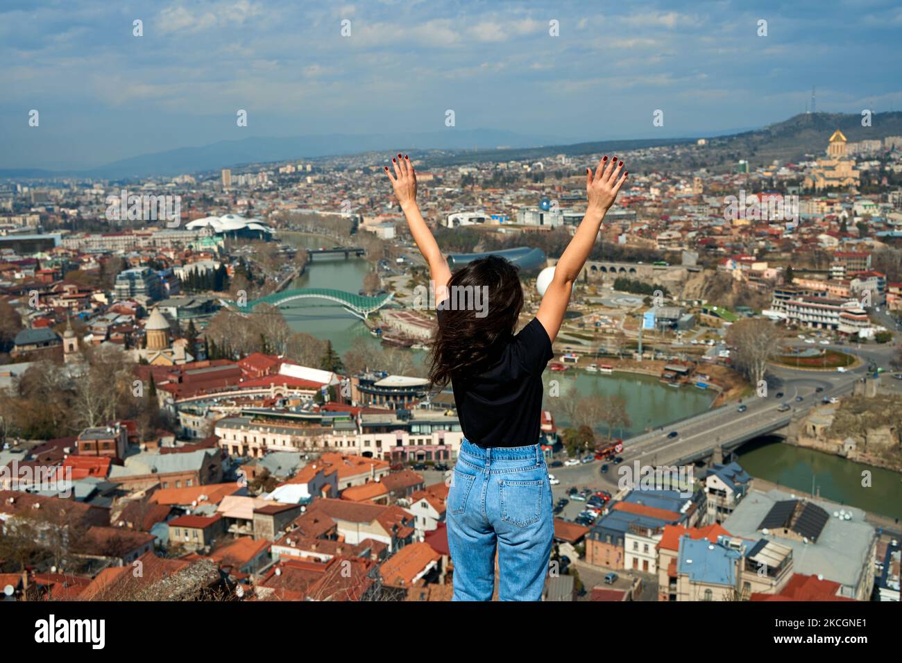 A cute brunette girl enjoys the stunning scenery of Tbilisi from the ...