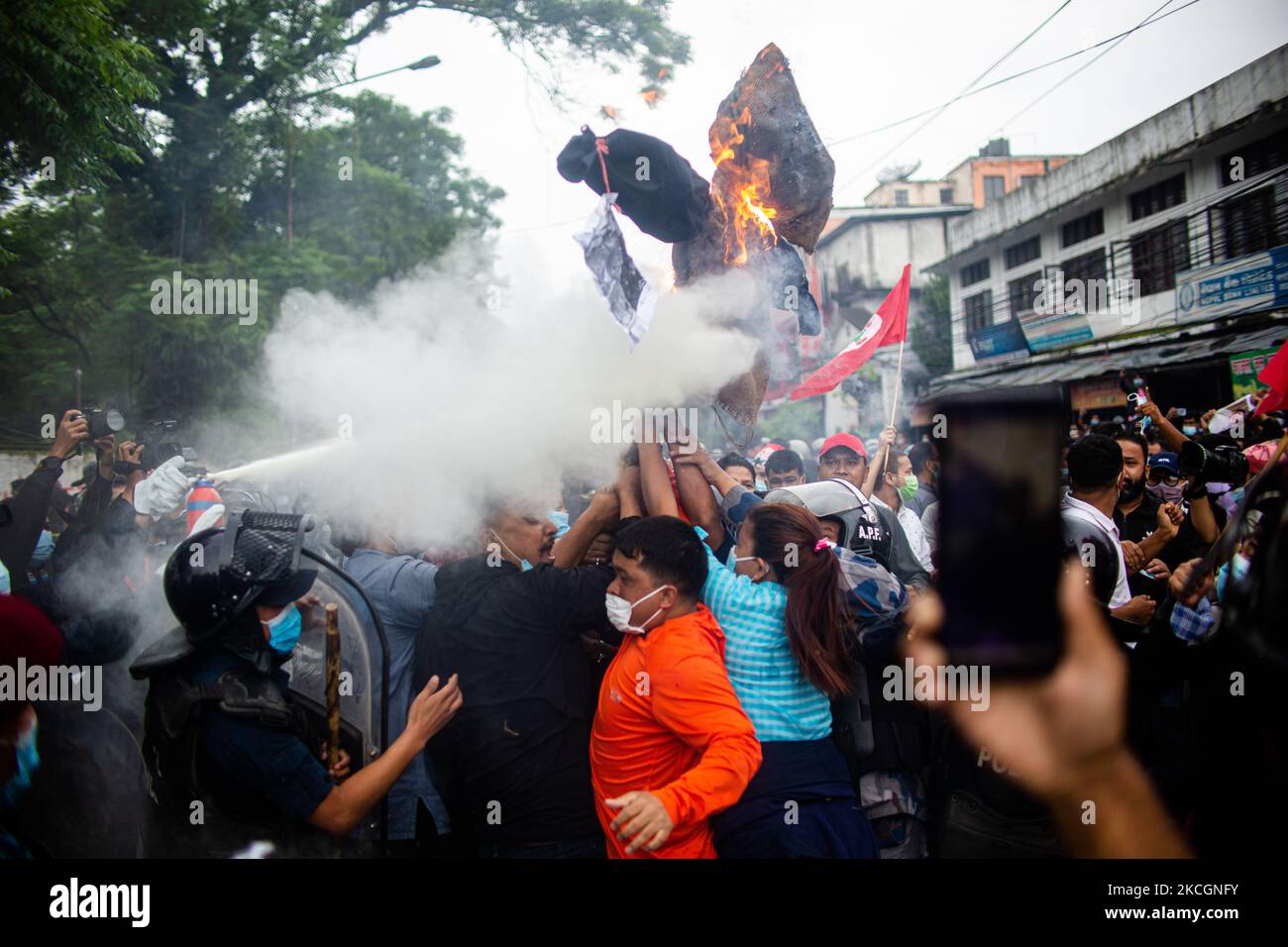 Nepal Police try to extinguish the burning effigy of Prime Minister KP ...