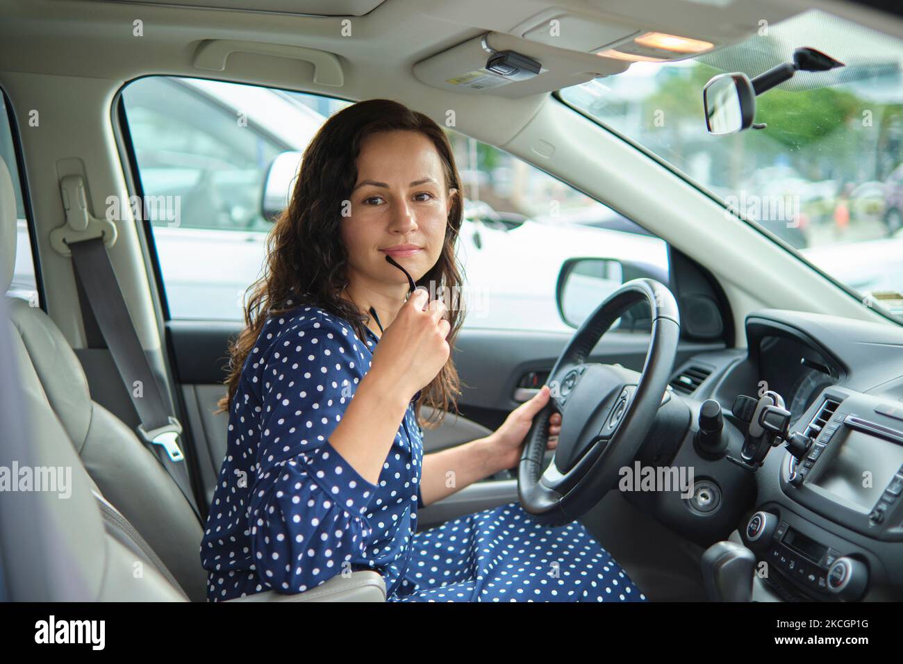 Portrait of attractive young woman in casual dress looking over her ...