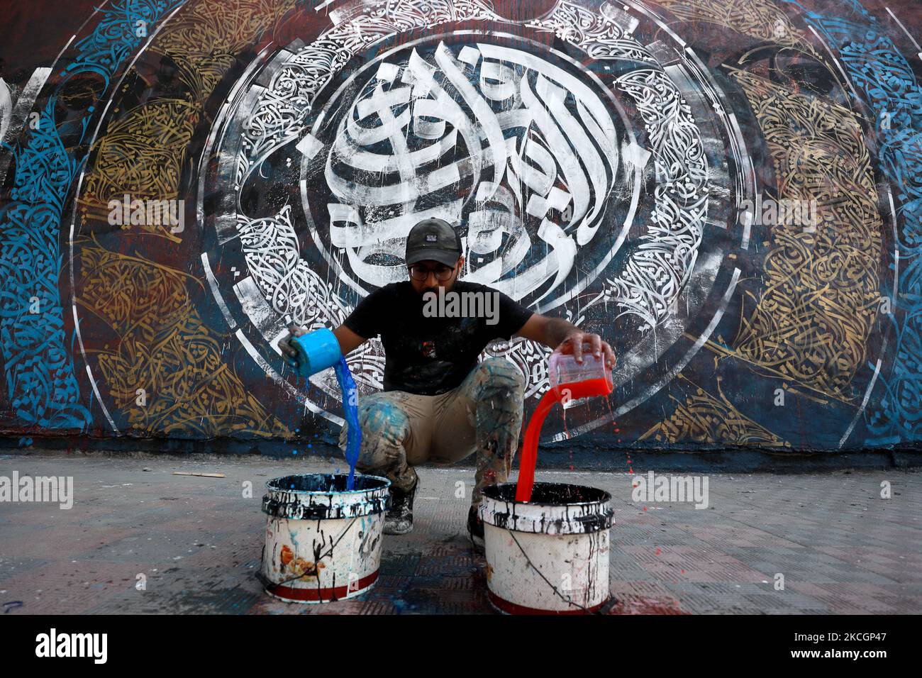 Palestinian artist Bilal Khaled draws on a wall ordinate in Gaza city ...