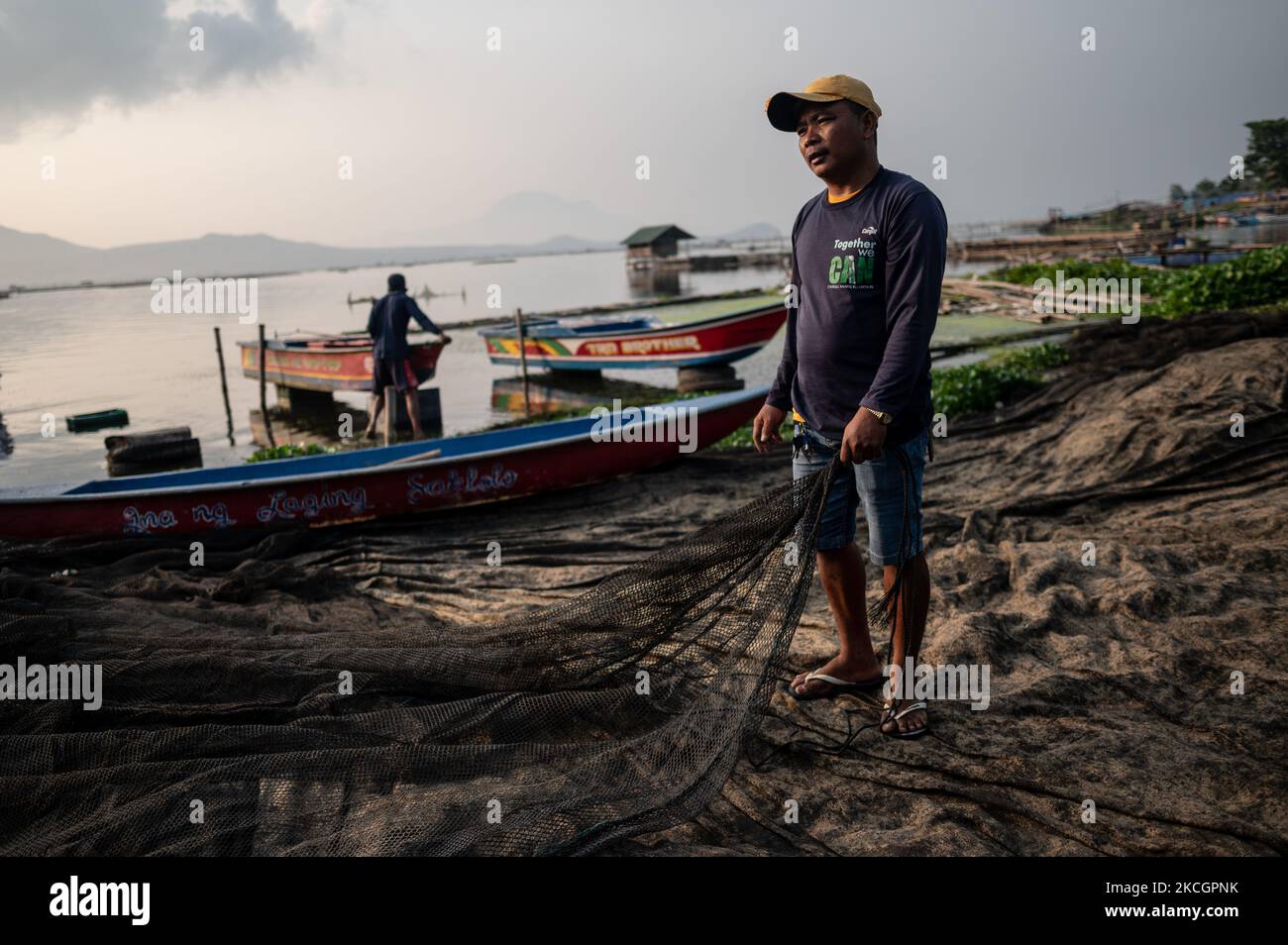 A fisherman holds a fishing net as they resume fishing in Taal Lake in ...