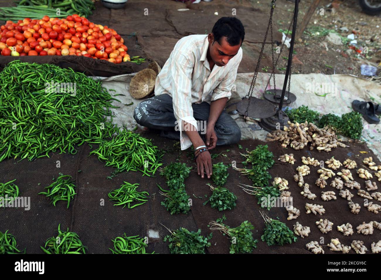 Vegetable vender prepares for customers at the Shaniwaar Subzi Bazaar ...