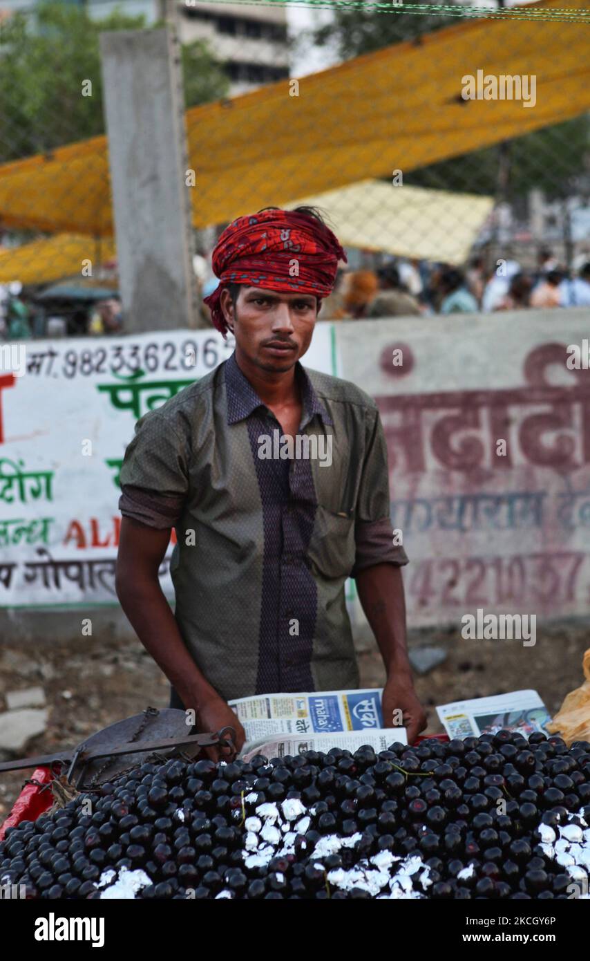 Merchant selling jammun fruit at the Shaniwaar Subzi Bazaar, which is ...