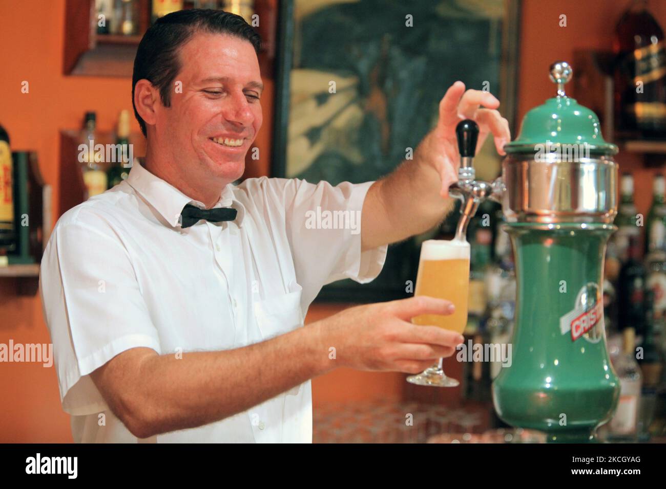 Bartender pours Cristal Beer (a typical Cuban beer) at a bar in ...