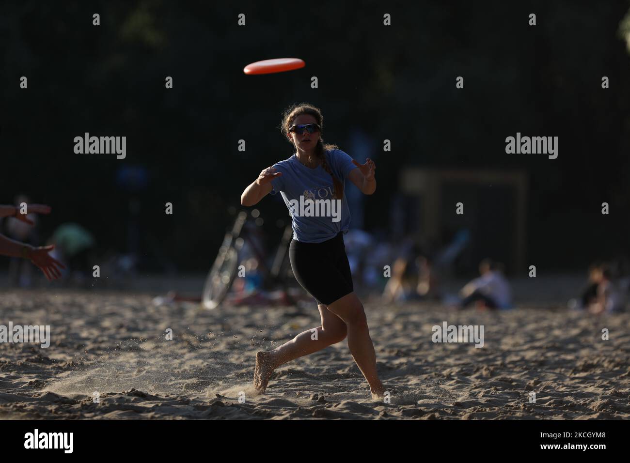People are seen playing competitive frisbee at a beach in Warsaw ...