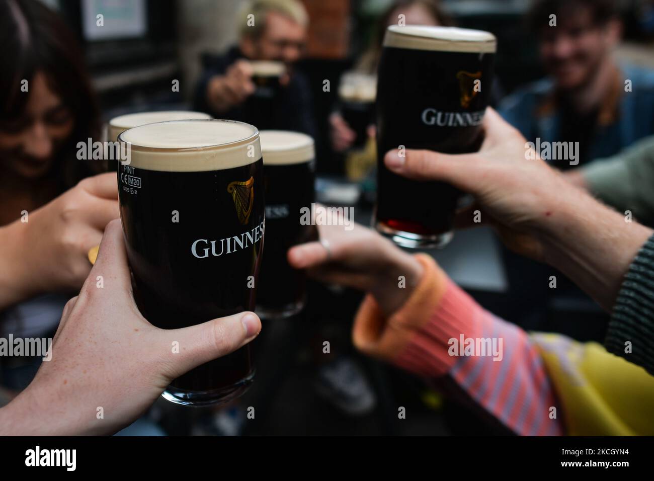 People enjoy drinking Guinness outside a pub in Dublin city center. On ...